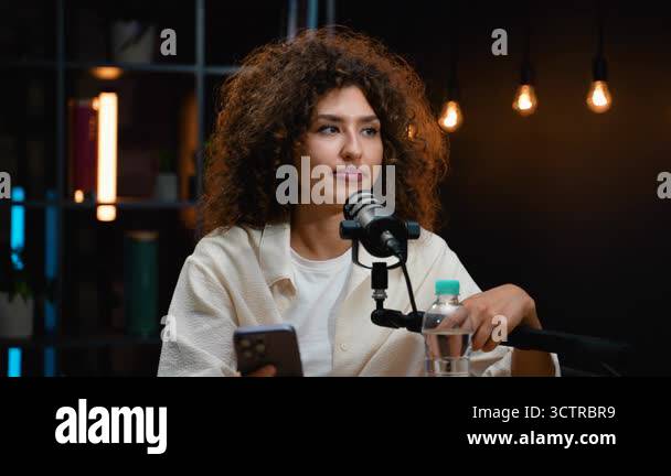 Young woman with curly hair speaking passionately into a professional ...
