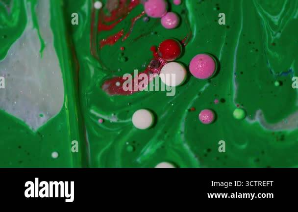 Paint fluid. Liquid background. Blur green red pink color oil ink in ...