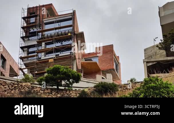 An aerial view captures a large building on a scenic hill, surrounded ...