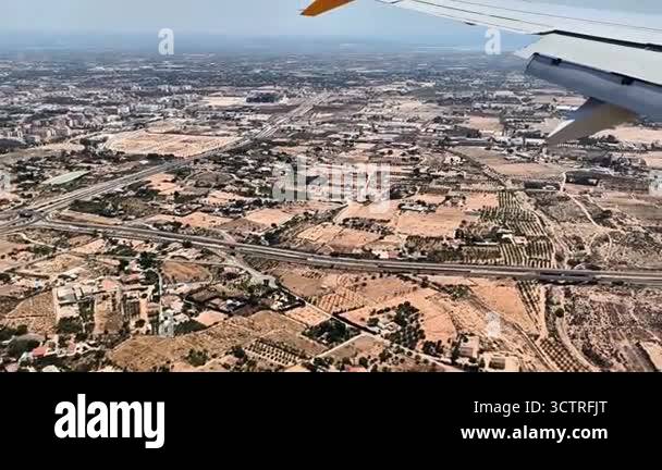 Experience breathtaking aerial views of urban landscapes from an airplane window. This ...