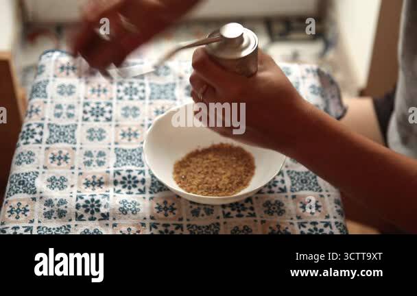 Grinding Flax Seeds. A close-up video of hands using a manual grinder ...