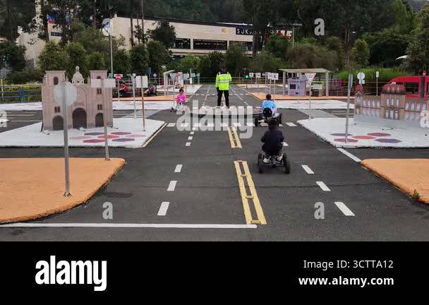 Cuenca, Ecuador: May 3 2025: Long shot of children driving small go ...