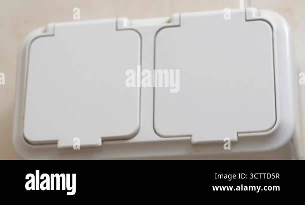 A man hand inserts a plug into an electrical outlet. Plug is insert ...