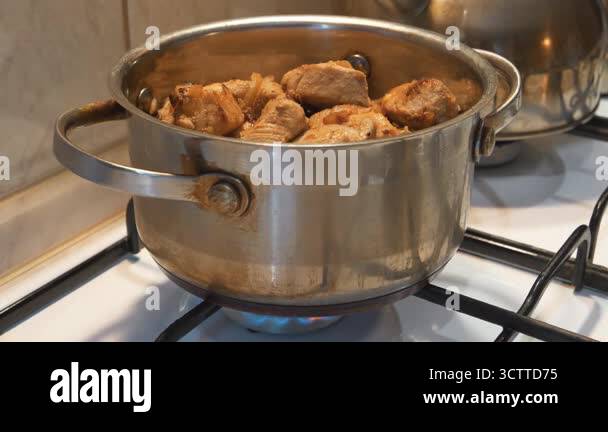 Cooking. Meat is stewing. There is a pot of meat on the gas stove, zoom ...