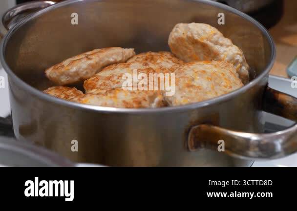 Meat cutlets are stewed in saucepan after being fried in a frying pan ...