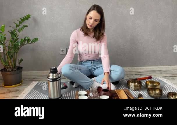 A peaceful tea ceremony. A womans hand pours green tea into a tea cup ...