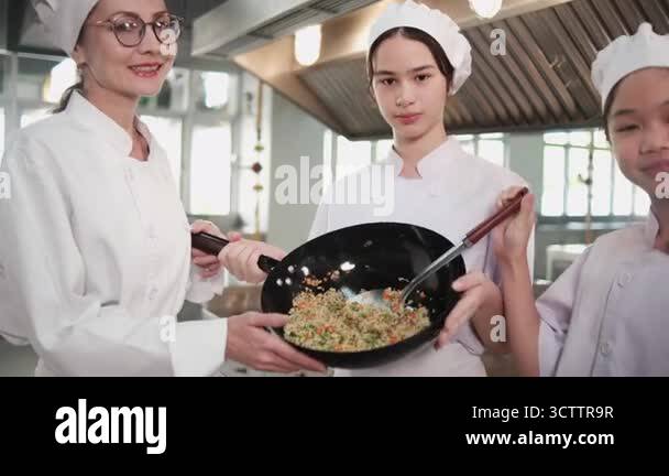 Teenage trainee girls in white aprons are proud to show fried rice in ...