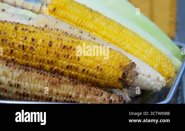 grill octopus Grilling corn on the cob at a vibrant street food market ...