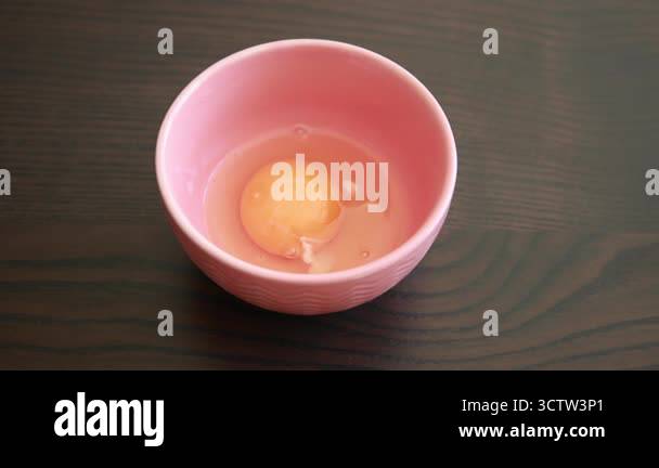 A close-up stock video of a broken raw egg in a small bowl Stock Video ...