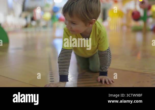 Cute little boy crawling on the floor, then standing up for the first ...