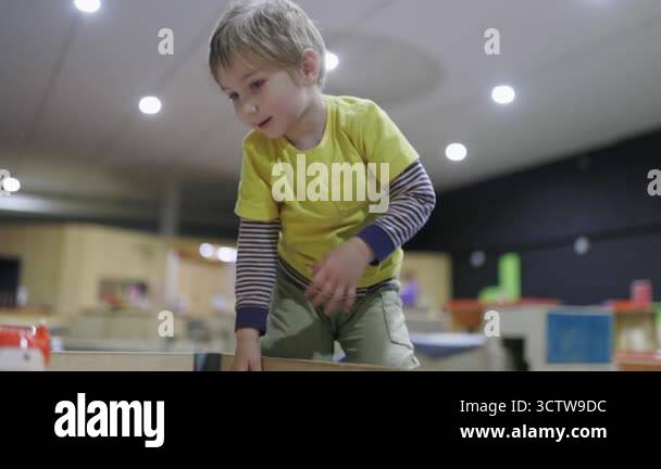 Young toddler playing and eating a snack in a modern and brightly lit ...