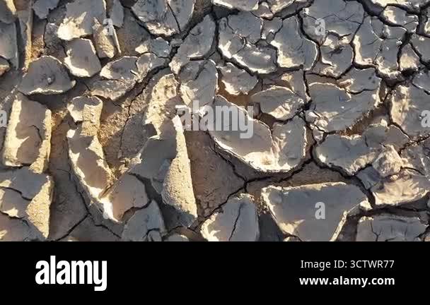 Severe drought cracks the land, exposing deep, dehydrated soil fissures ...