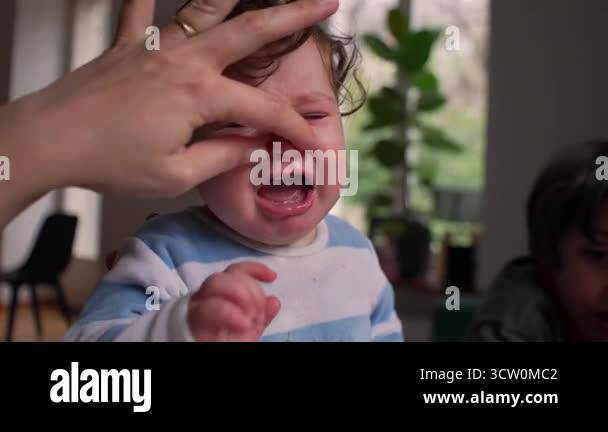 Close up of baby crying with hand reaching to wipe nose, emotional ...