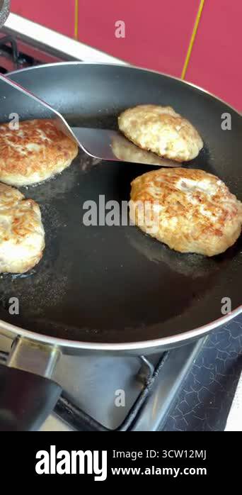 Unhealthy high cholesterol food. Frying patties in a pan with lots of ...
