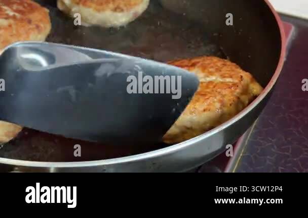 Unhealthy high cholesterol food. Frying patties in a pan with lots of ...