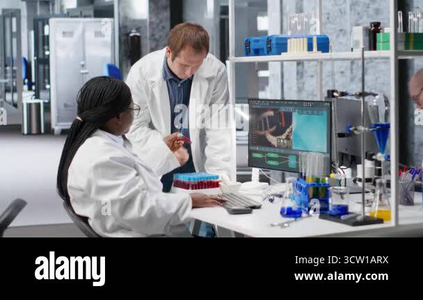 Colleagues in research lab analyzing flasks and chemical samples for ...