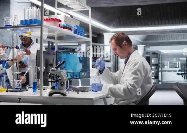 Male scientist handles pipette with droplet over jar during procedure ...