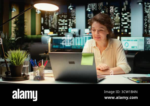 Businesswoman joins an online meeting at night in corporate office ...