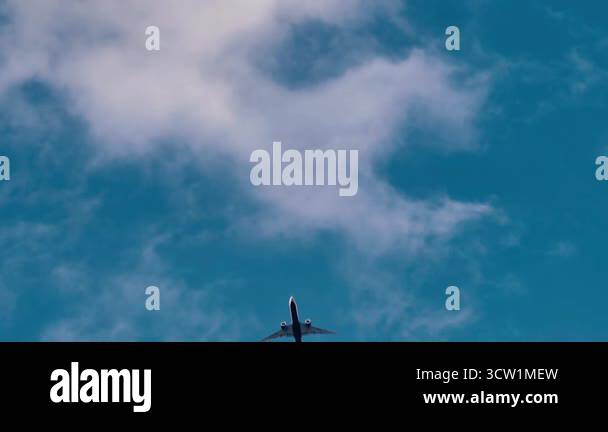 A passenger plane disappears behind the clouds. Shot from below Stock ...