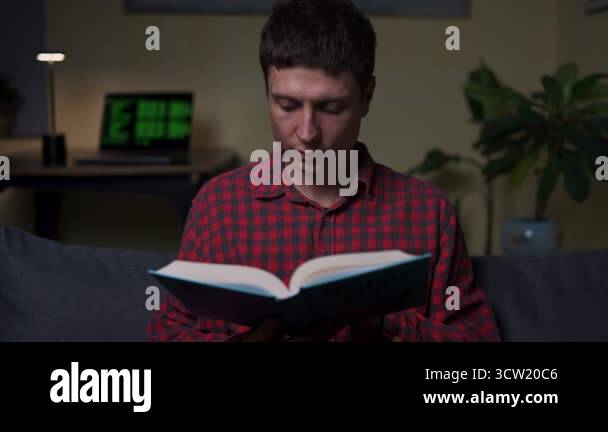 Man reading a book instead of using laptop, symbol of digital detox and ...