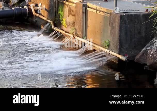 Water flowing through pipes into a stream Stock Video Footage - Alamy