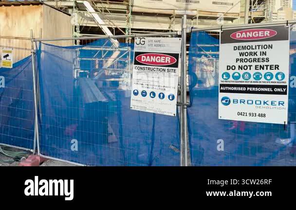Warning signs on a construction site fence in bright daylight ...