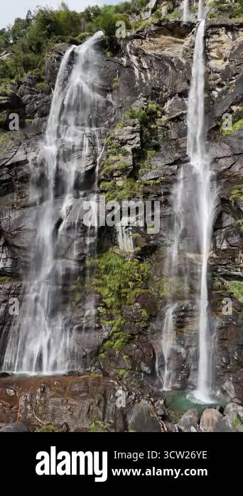 Scenic waterfall flowing down rocky cliff surrounded by green forest in ...