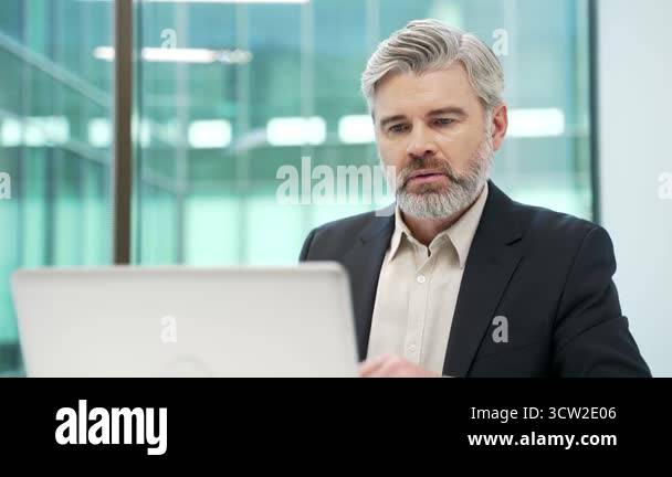 Thoughtful businessman working on laptop in business office. Manager ...