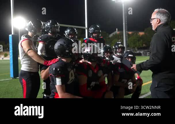 Enthusiastic coach giving a motivational speech to his american ...