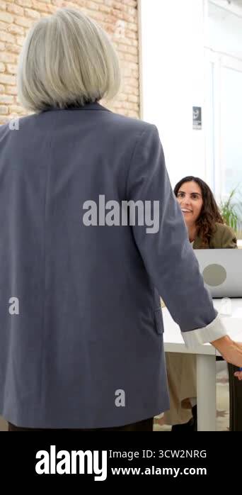 Experienced female manager with grey hair actively mentoring a diverse ...