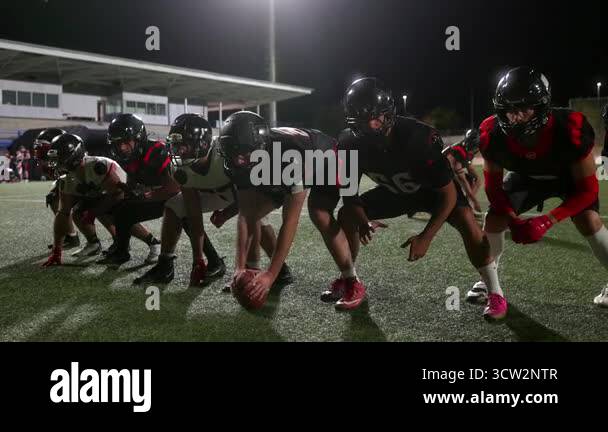Two opposing american football teams facing each other at the line of ...