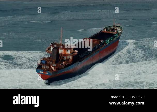 Aerial view, top view of old rusty stranded logistics ship on the beach ...