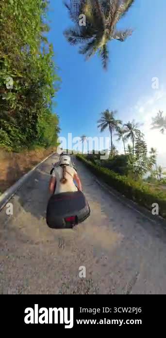 Vertical video. Woman Sitting Behind Man on Scooter Driving Uphill ...