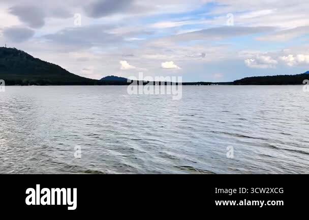 A calm and tranquil lake scene featuring gentle waves lapping as ...