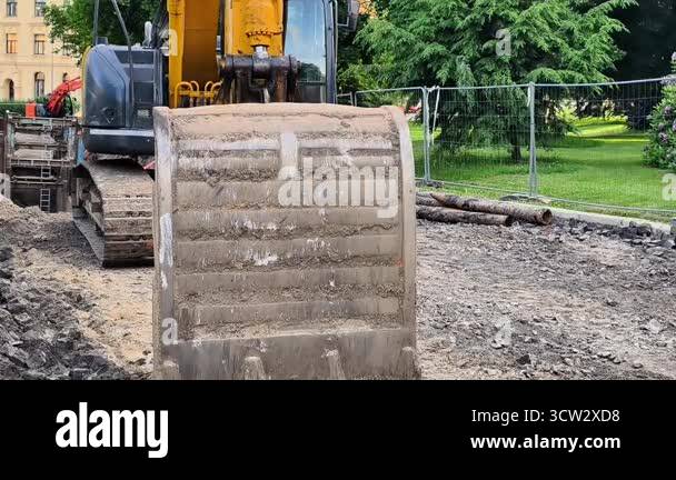 An excavator is digging at the construction site, clearing the area for ...