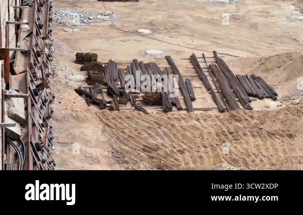 At a construction site located on dry terrain, metal rails and pipes ...