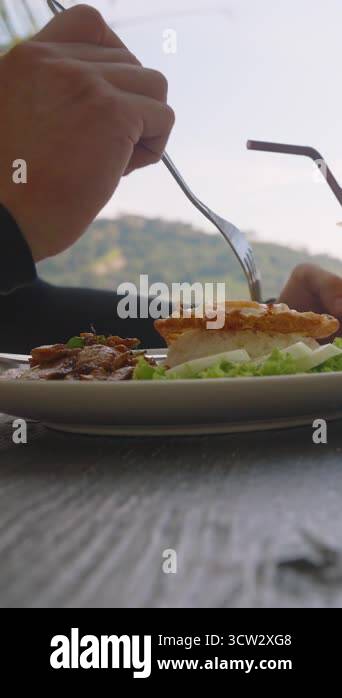 Vertical video. Man Eating Chicken Rice and Burger Meal While Drinking ...
