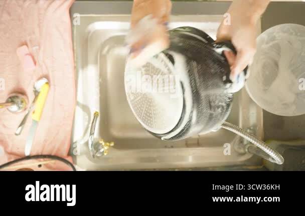 Overhead View of Person Washing Large Pot with Soapy Sponge in Sink ...