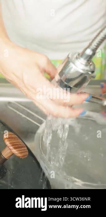 Vertical video. Woman Washing Small Kitchen Utensil Under Running Water ...