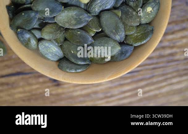 Close-up of raw green pepitas, a nutritious superfood snack, slowly ...