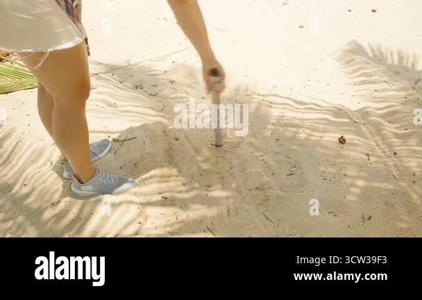 Woman Drawing a Heart Shape in the Sand Using a Stick While Standing ...