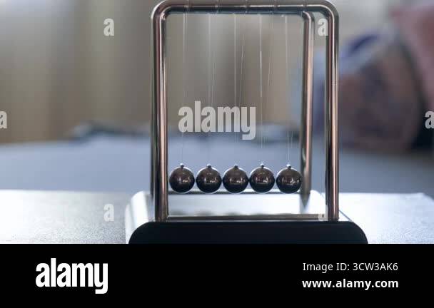 Hand Running Newtons Pendulum Close-Up Stock Video Footage - Alamy