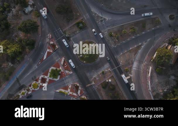 Aerial drone footage showing a city roundabout and multiple road ...