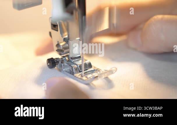 Close-up view of sewing machine needle and presser foot with thread ...