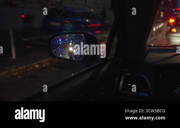 View of ambulance with flashing blue lights reflected in car side ...