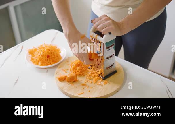 Woman Grating Carrots on Box Grater with Pile of Shredded Carrots ...