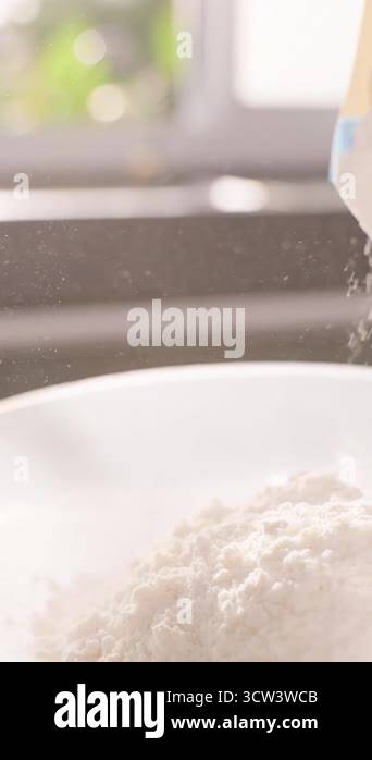 Vertical video. Flour Pouring from Package into White Bowl with ...