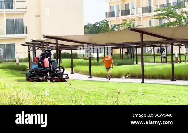 Man mowing grass near a building Stock Video Footage - Alamy