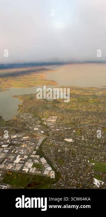 Aerial view of Auckland, New Zealand, transitioning from clear skies to ...