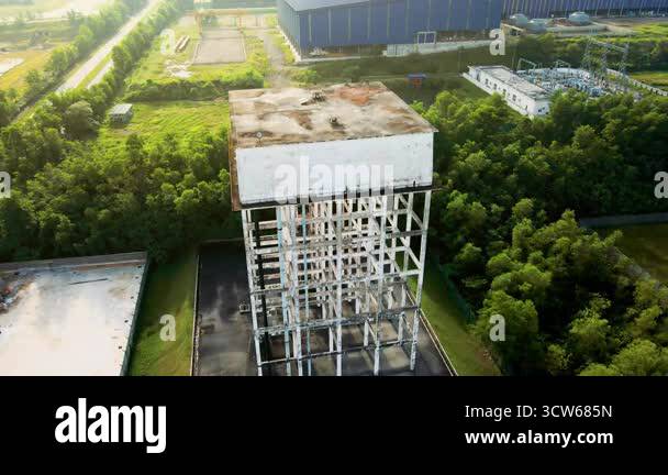 Aerial drone view of an old elevated water tank structure surrounded by ...